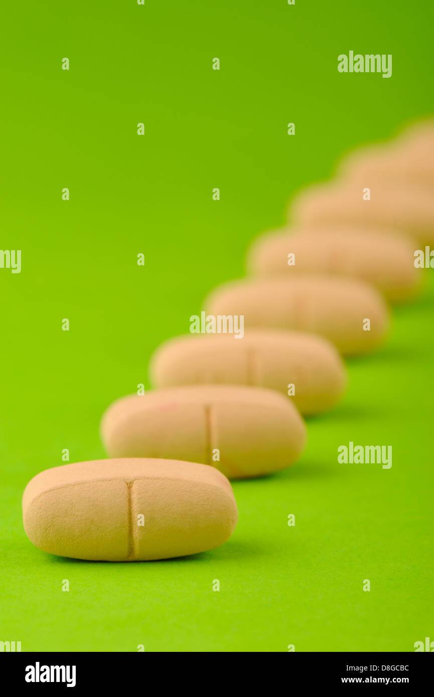 set red tablets on green background Stock Photo - Alamy