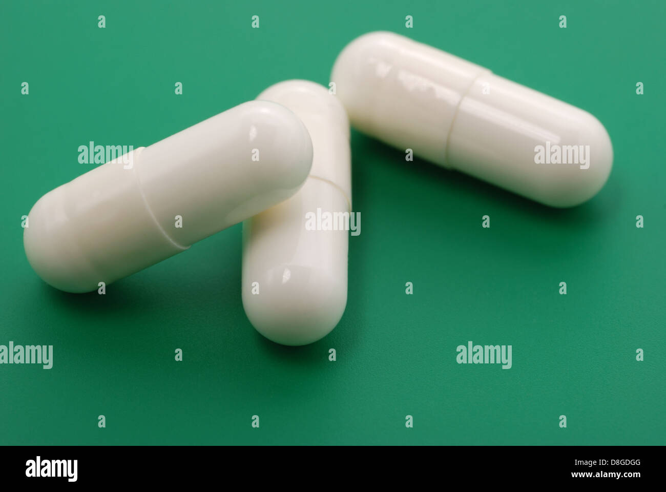 White tablets at green background Stock Photo - Alamy