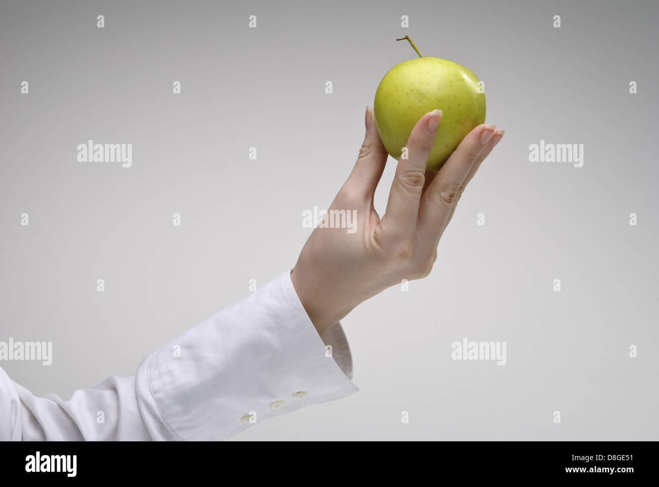 Woman's hand holding an apple Stock Photo - Alamy