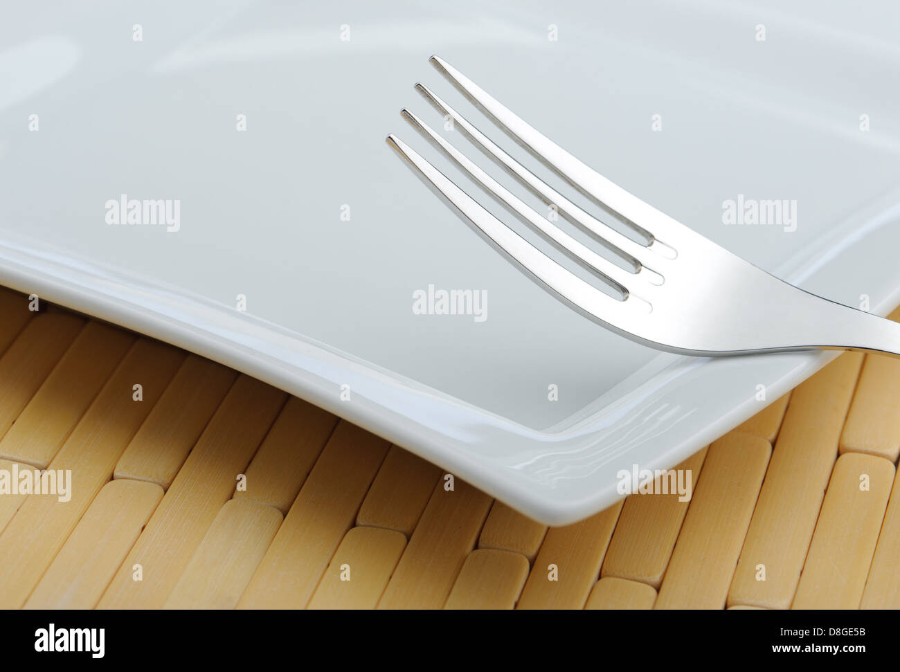 Fork laying on a plate Stock Photo - Alamy