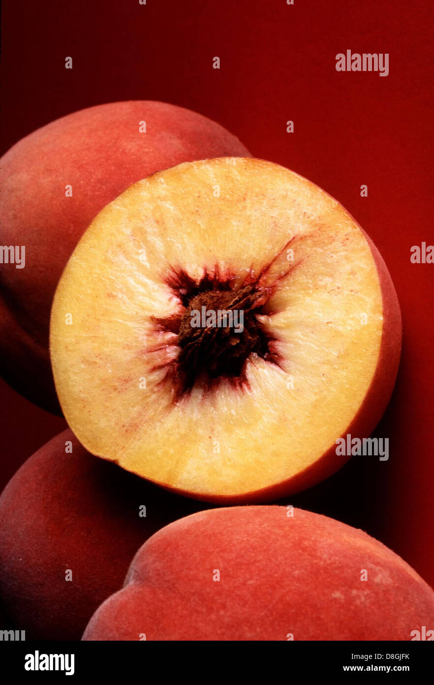 A close-up of a ripe autumn red peach, showing its vibrant color and ...