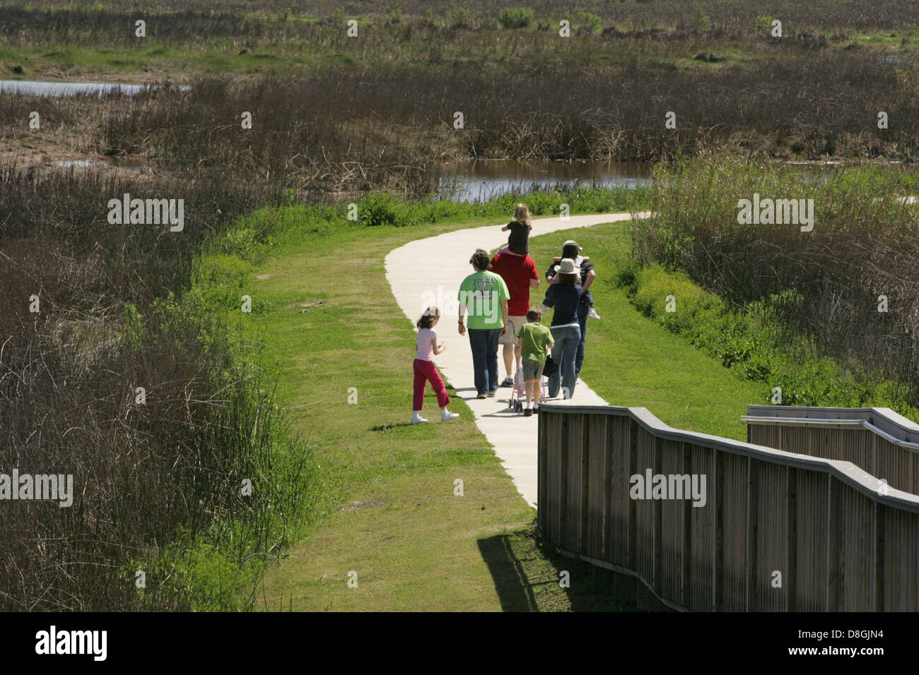 A family strolls through a scenic outdoor path, enjoying each other's ...