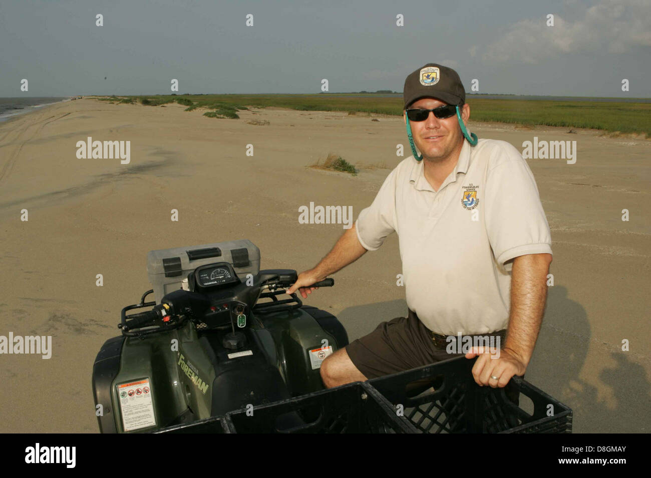 Beach patrol officers on a terrain vehicle, monitoring the area for ...