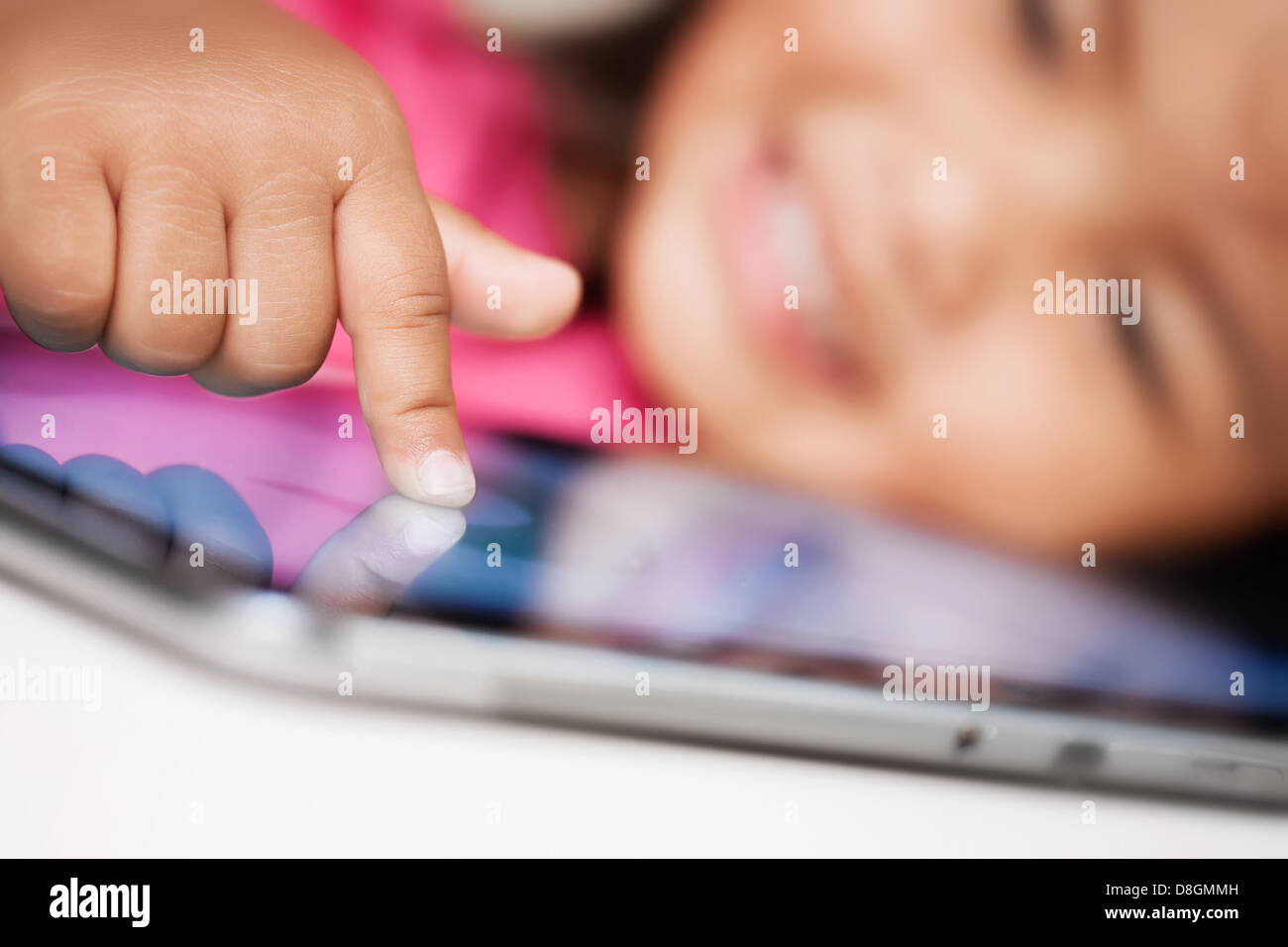 A happy kid selecting or pointing at something on a touchscreen tablet ...