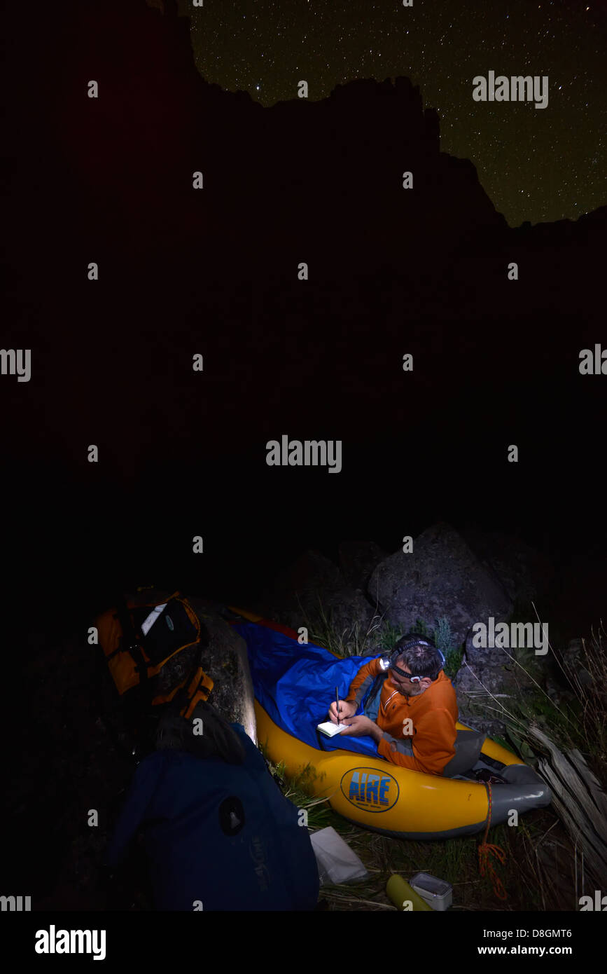 Kayaker sleeping in inflatable kayaks at a camp along the Jarbidge ...
