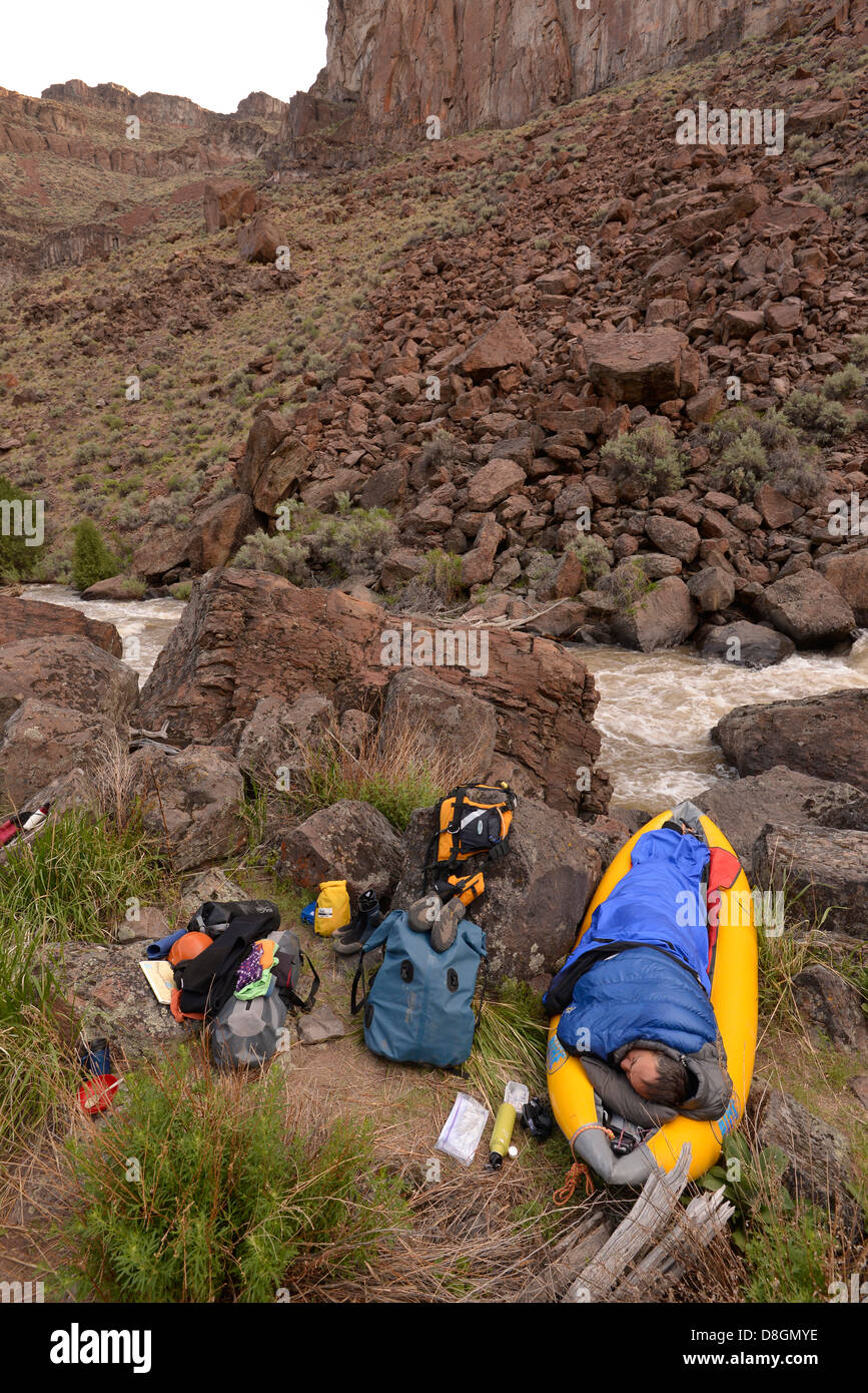 Kayaker sleeping in inflatable kayaks at a camp along the Jarbidge ...