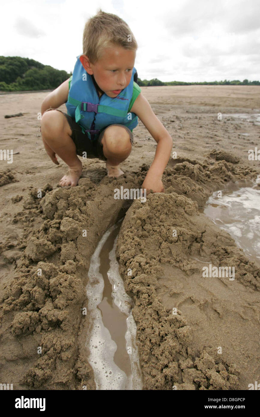 Boy playing in sand on beach Stock Photo - Alamy