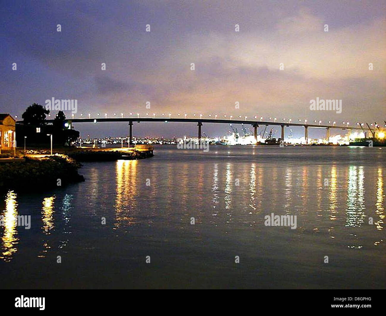 This image shows a bridge illuminated at night, with lights reflecting ...