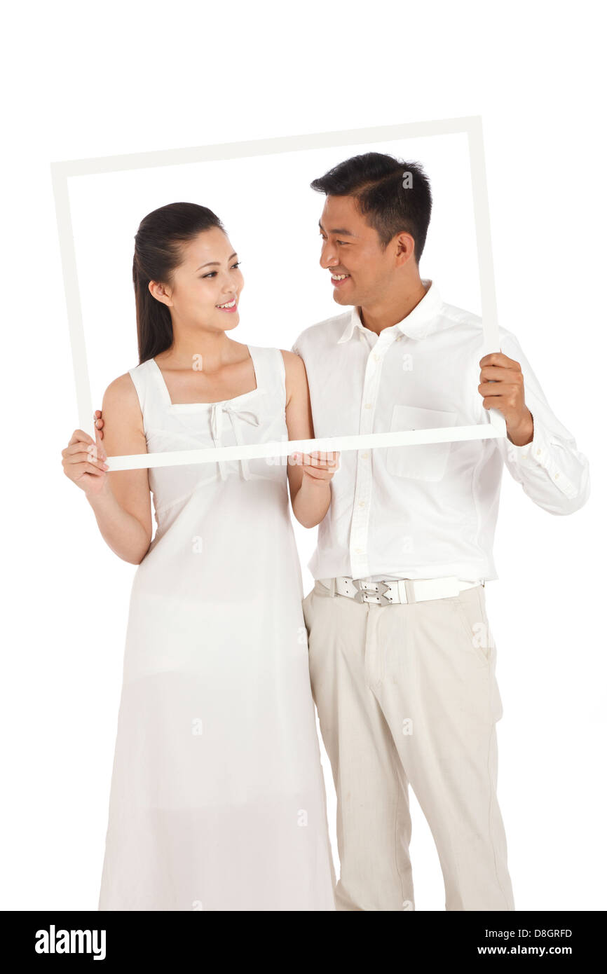 Young couple holding photo frame Stock Photo - Alamy