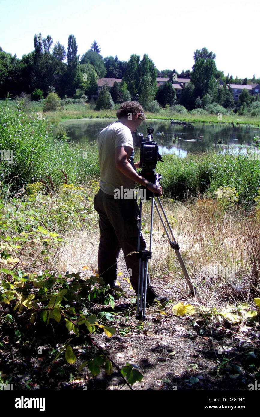 A cameraman filming nature scenes in the wild. The focus is on ...