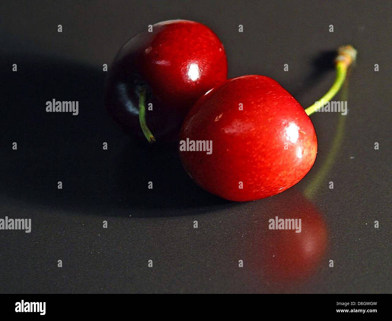 A close-up of fresh cherries, showcasing their glossy red skin and ...