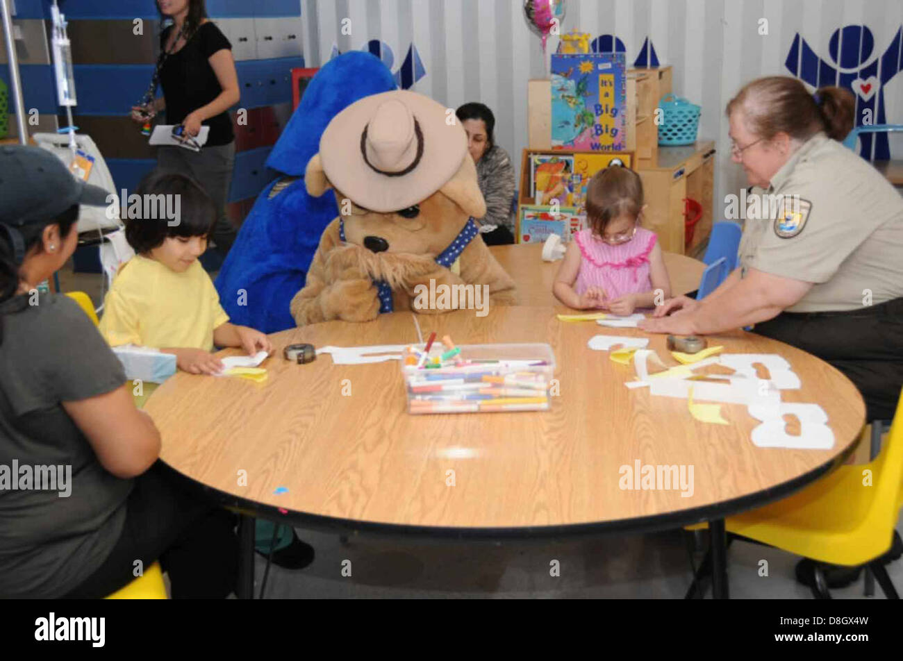 Children enjoy playing with a mascot character at an event. Mascots are ...