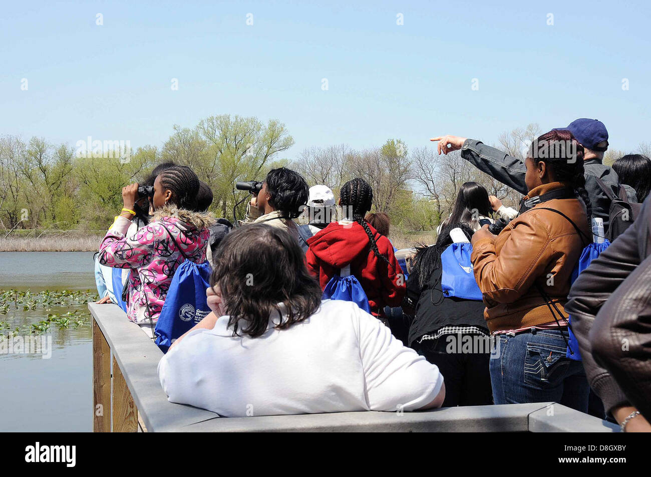 A group of children observing birds in a natural setting, with their ...