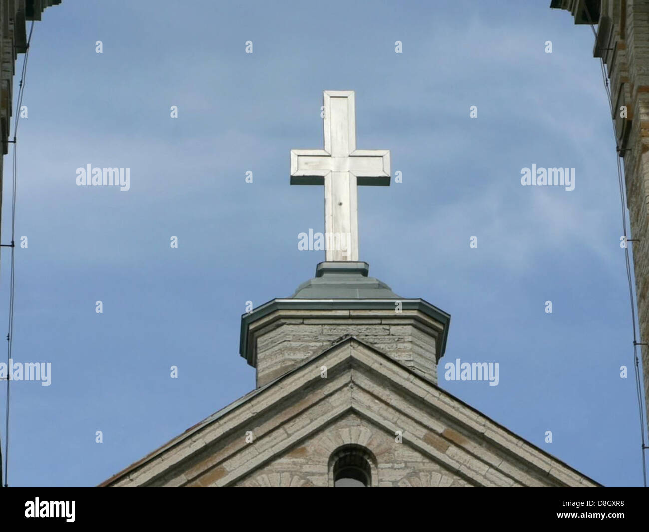 A church cross placed atop a steeple, symbolizing the Christian faith ...