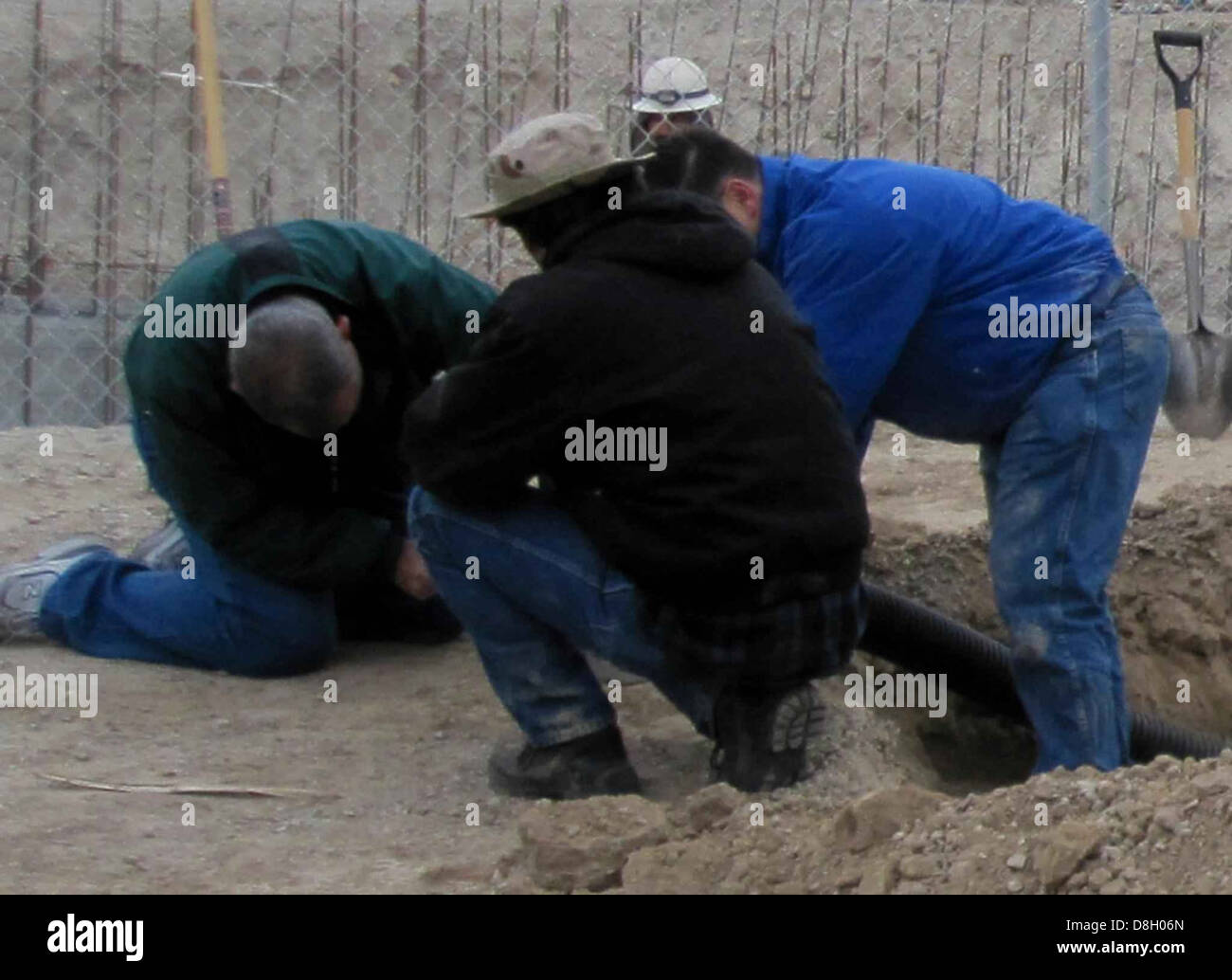 The image shows construction workers engaged in building or ...