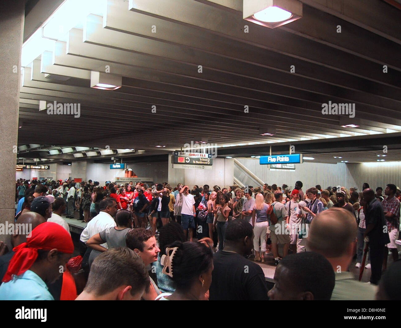 A diverse group of people gathered in a public space, forming a crowd ...