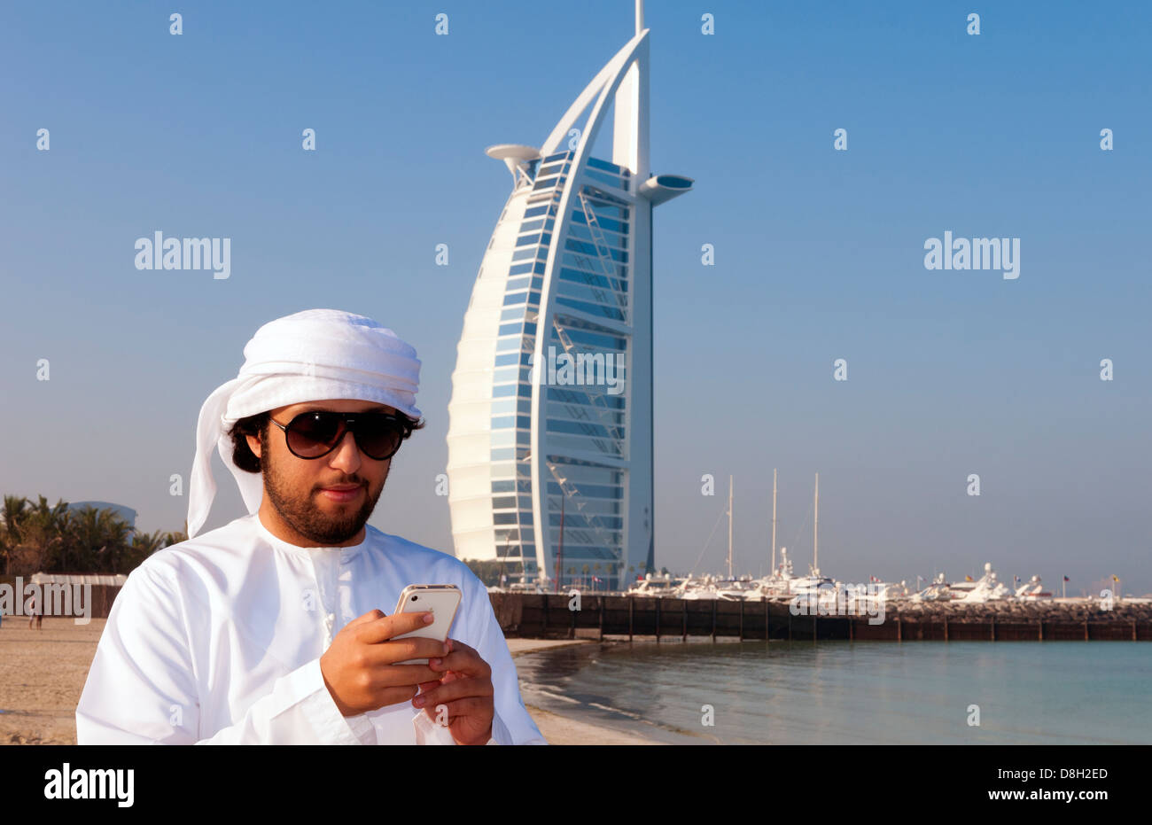 Emirate arab man with cell phone texting in front of Worlds only 7 star ...