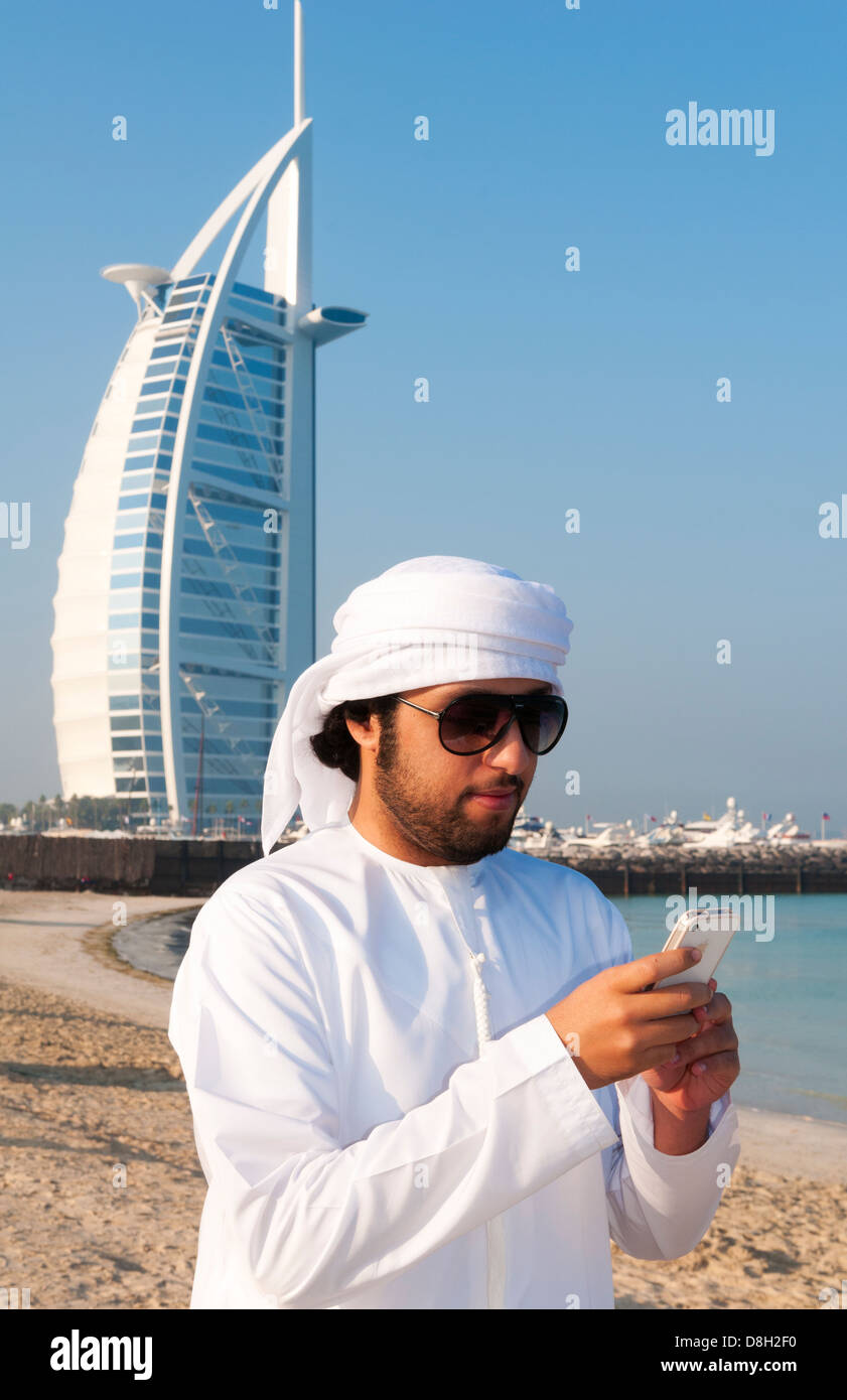 Emirate arab man with cell phone texting in front of Worlds only 7 star ...