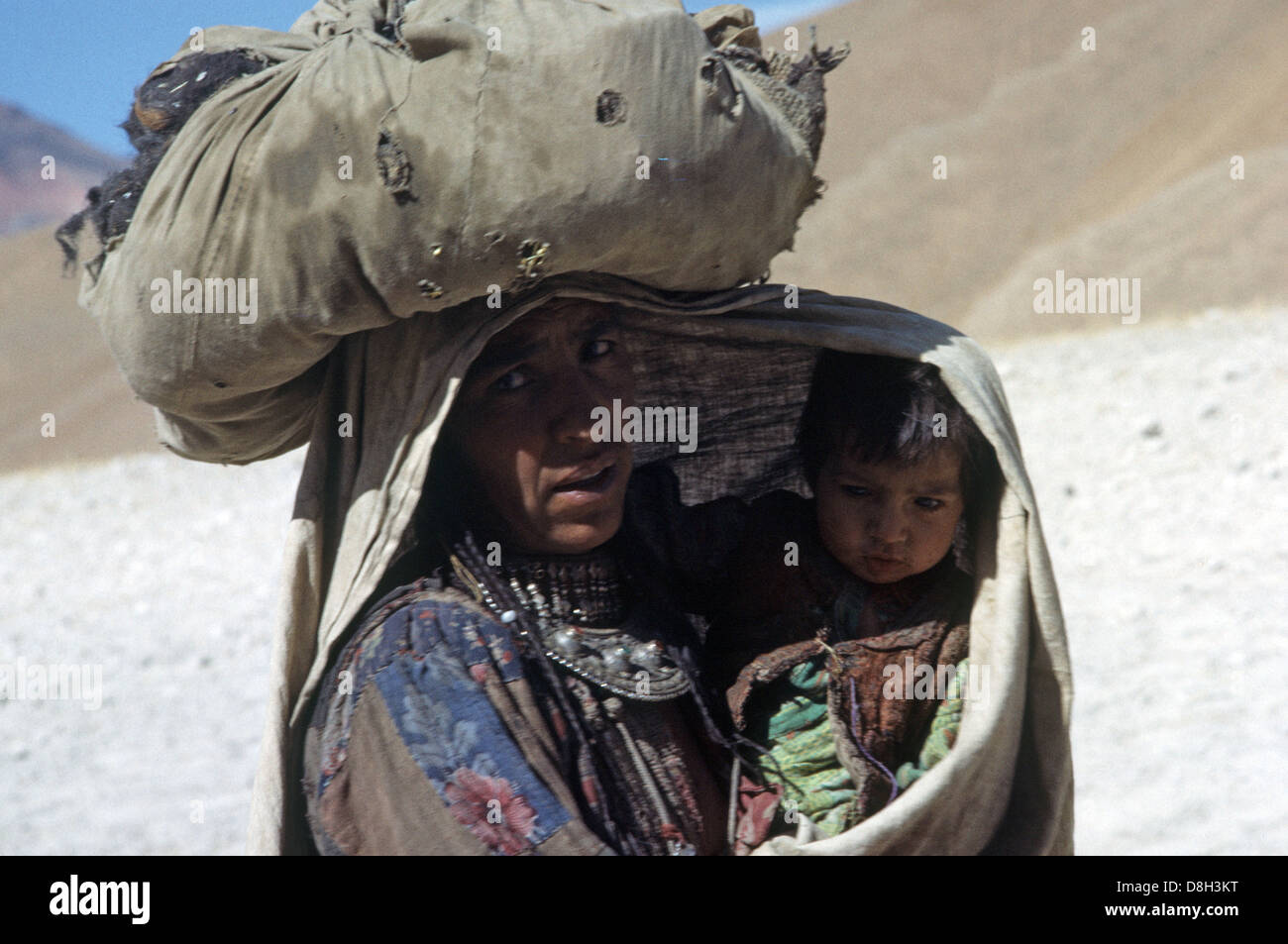 Afghanistan Nomadic mother and child shielding from the sun under a ...
