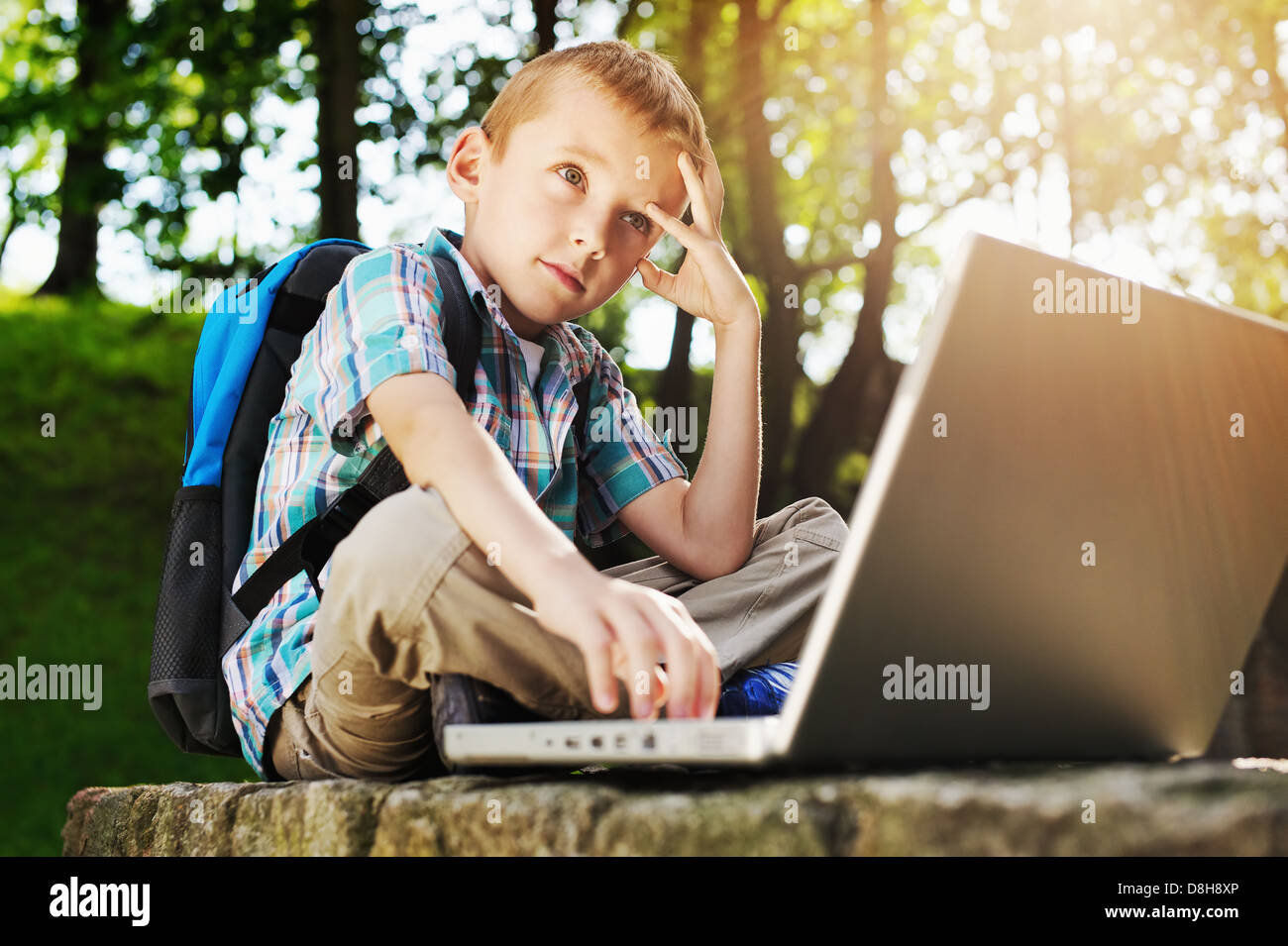 Thoughtful boy with laptop Stock Photo - Alamy