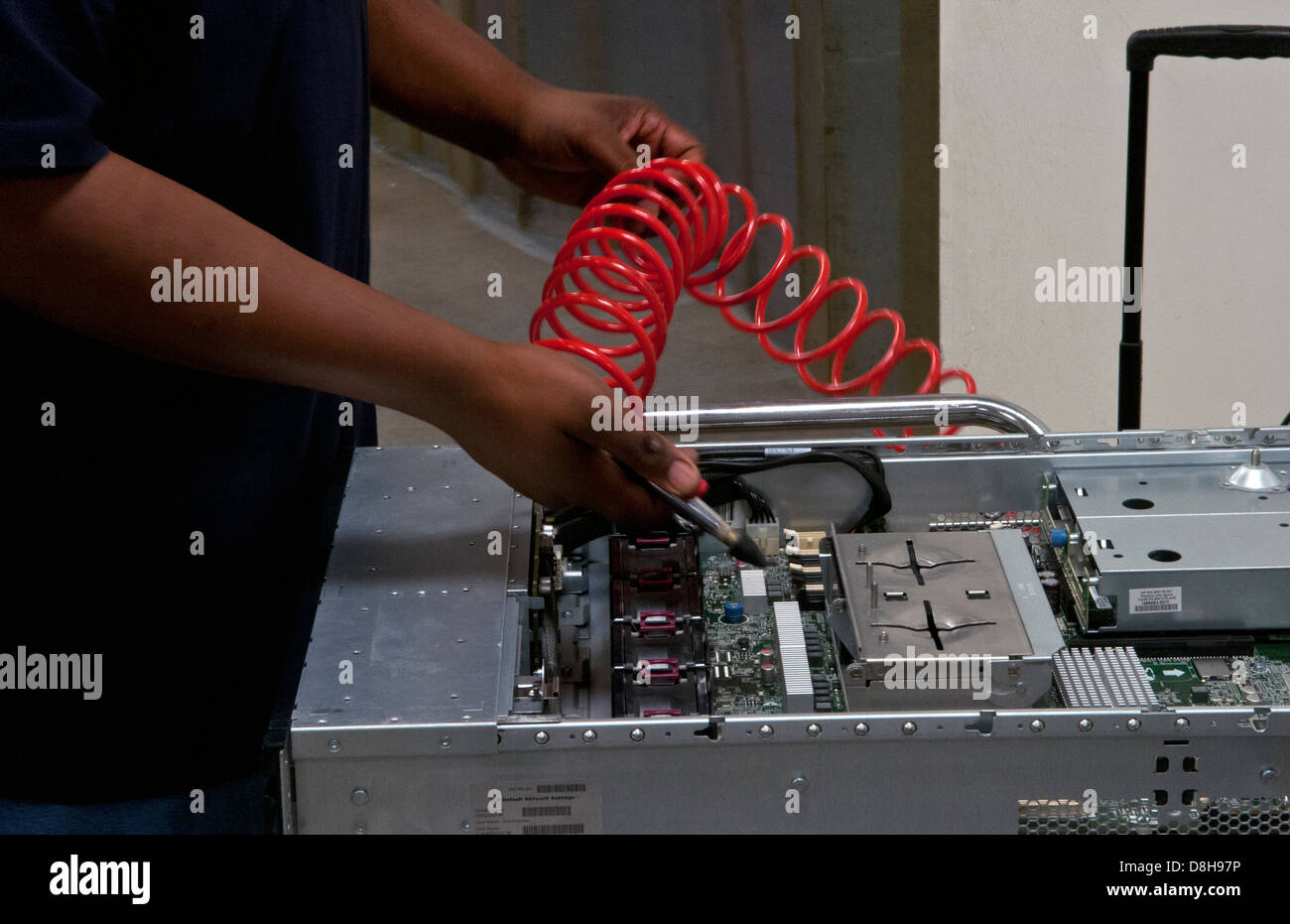man with air hose cleaning and assembling server for computer ...