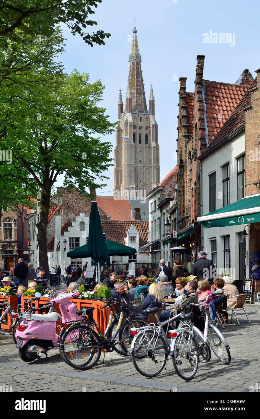 Street view of cafe life in Walplein, Bruges with Church of Our Lady in ...