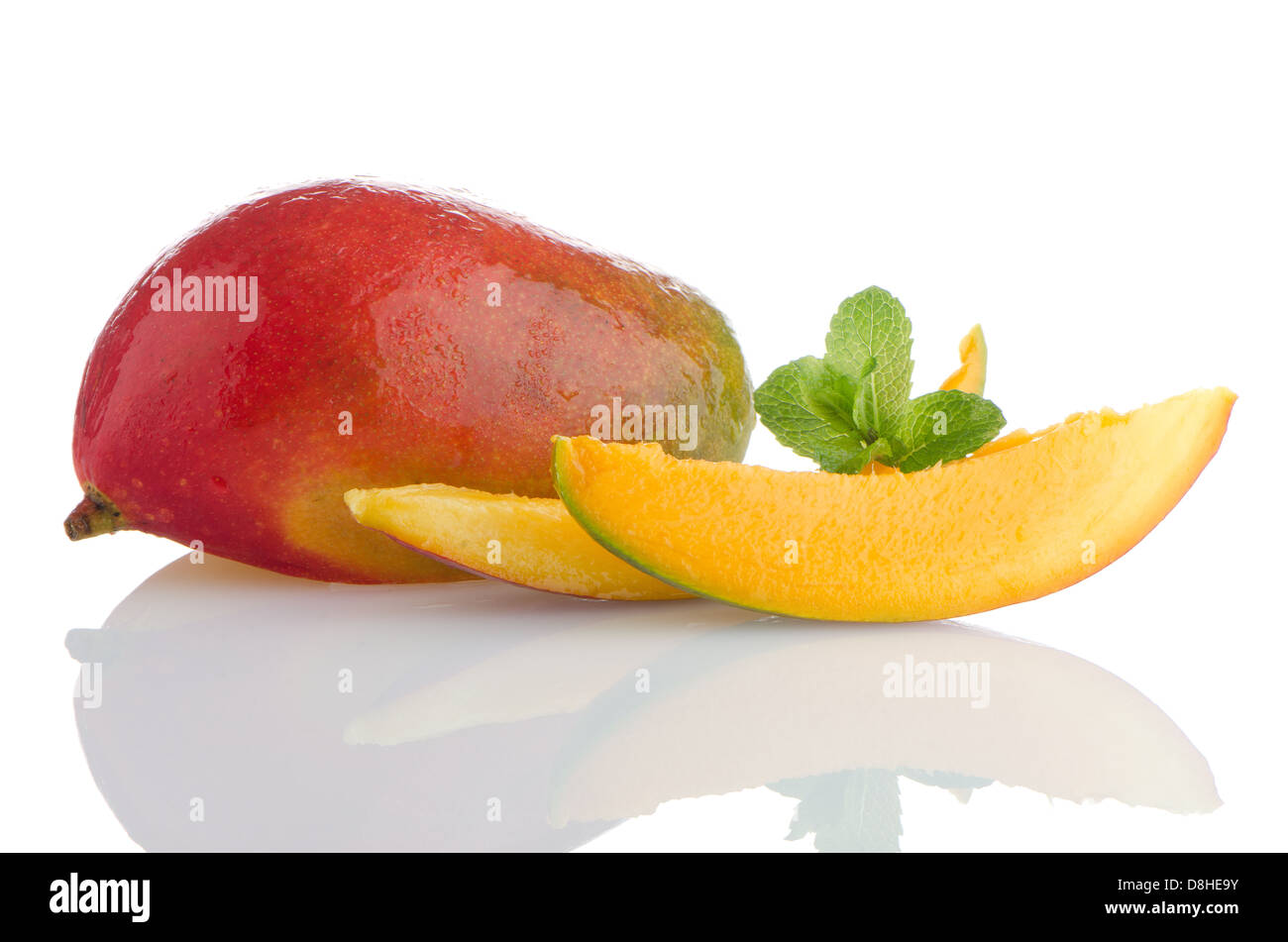 Mango fruit and slices on white reflective background Stock Photo - Alamy