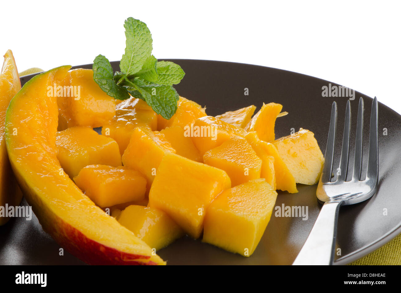 Mango fruit on brown plate on white background Stock Photo - Alamy