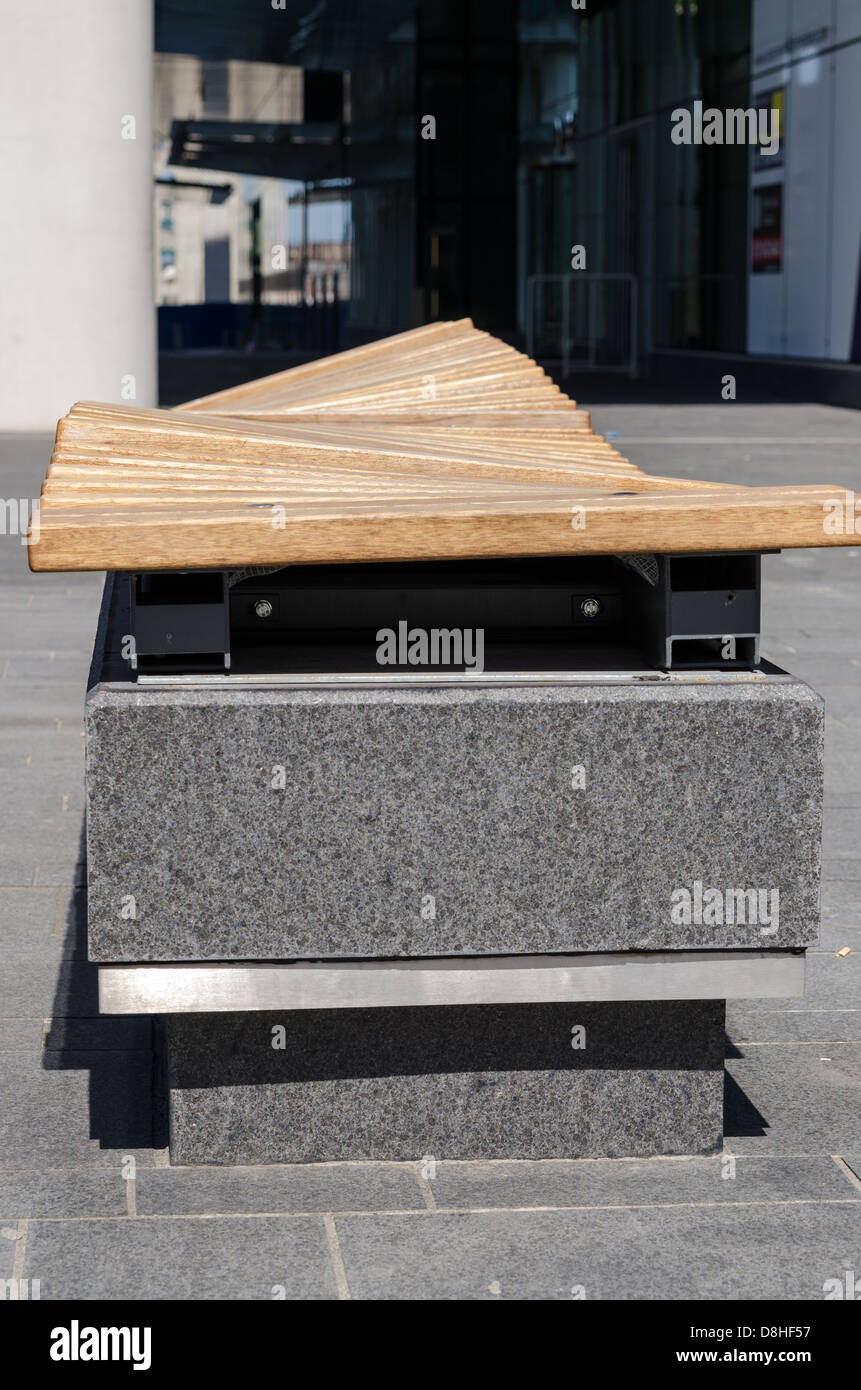 Curved wooden bench seat mounted on granite plinth at one snowhill ...