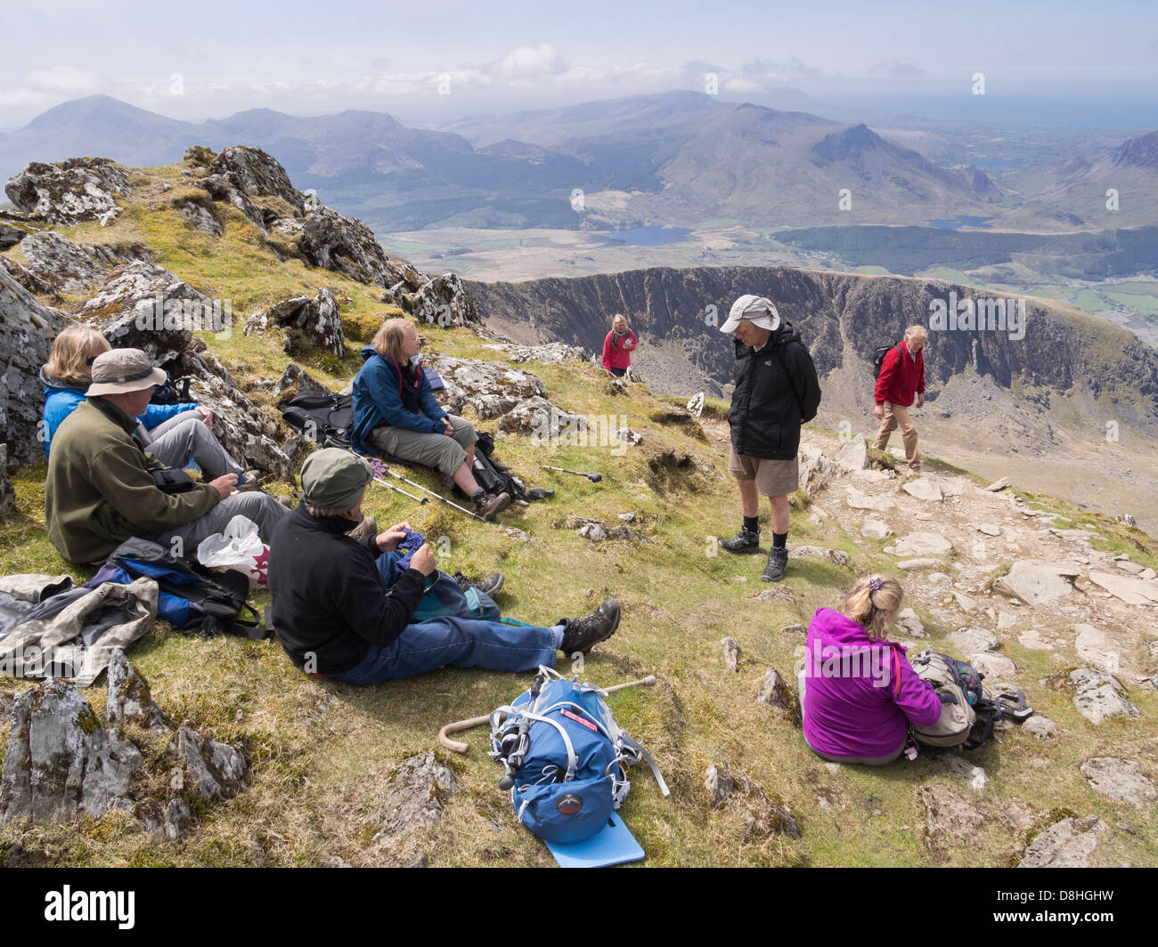 Ramblers resting by Rhyd Ddu path on Bwlch Main on Mt Snowdon with view ...