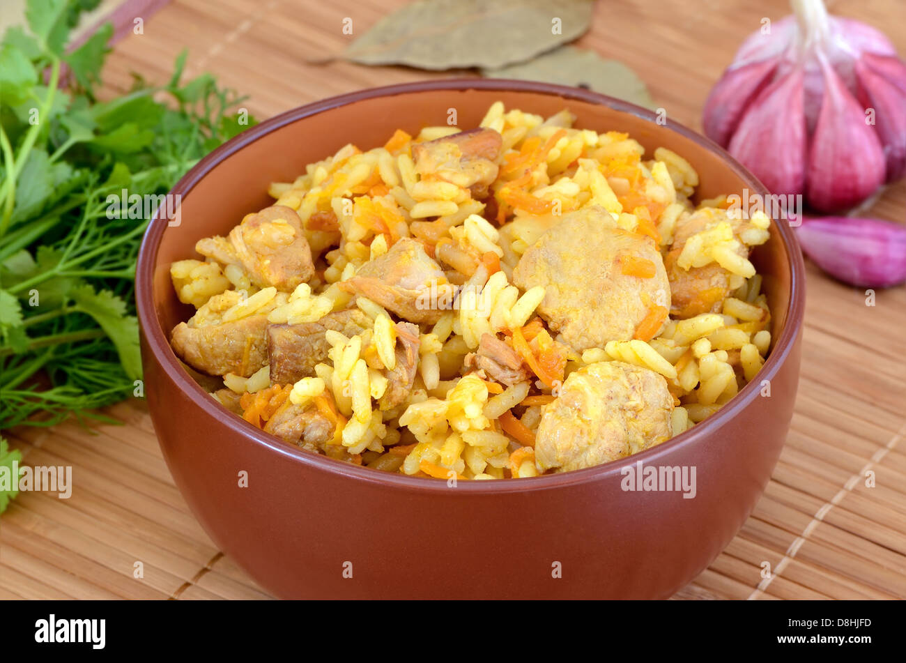 Pilaf in a brown bowl and vegetables on the table Stock Photo - Alamy