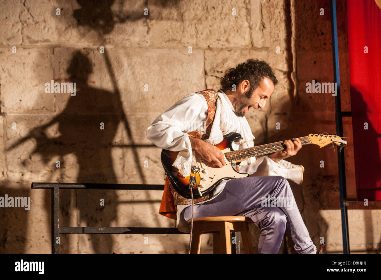 Jerusalem, Israel. A man plays an electric guitar. A shadow of a ...