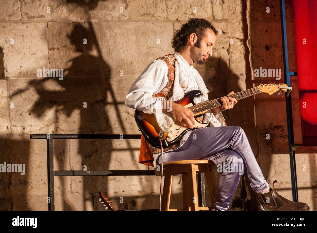 Jerusalem, Israel. A man plays an electric guitar. A shadow of a ...