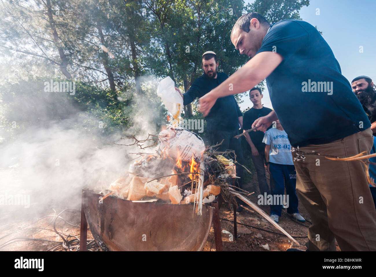 An Orthodox Jewish throws a bread and wheat produts into the fire as ...