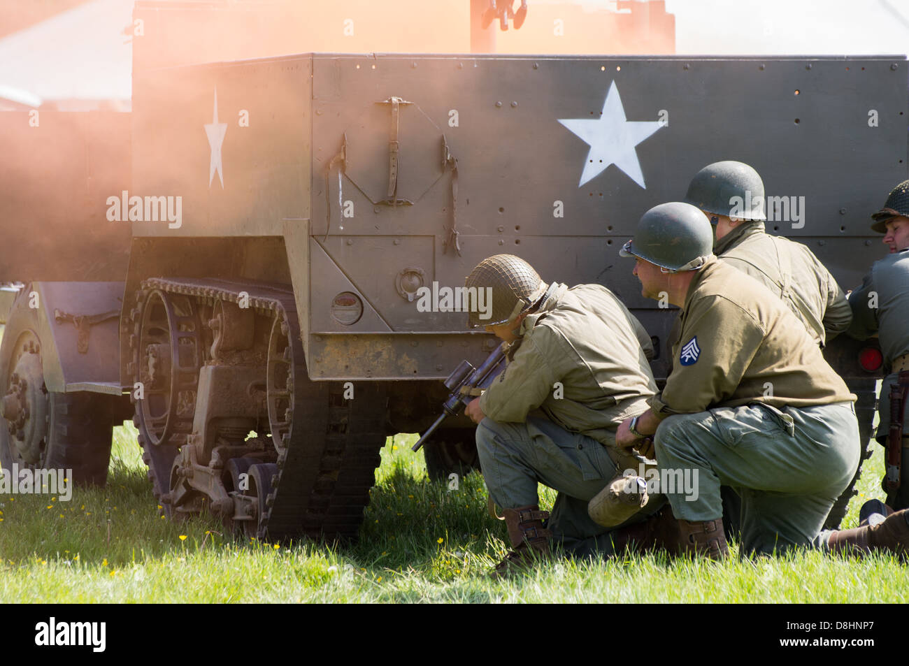 American soldiers take cover behind a Half Track Personnel carrier with ...