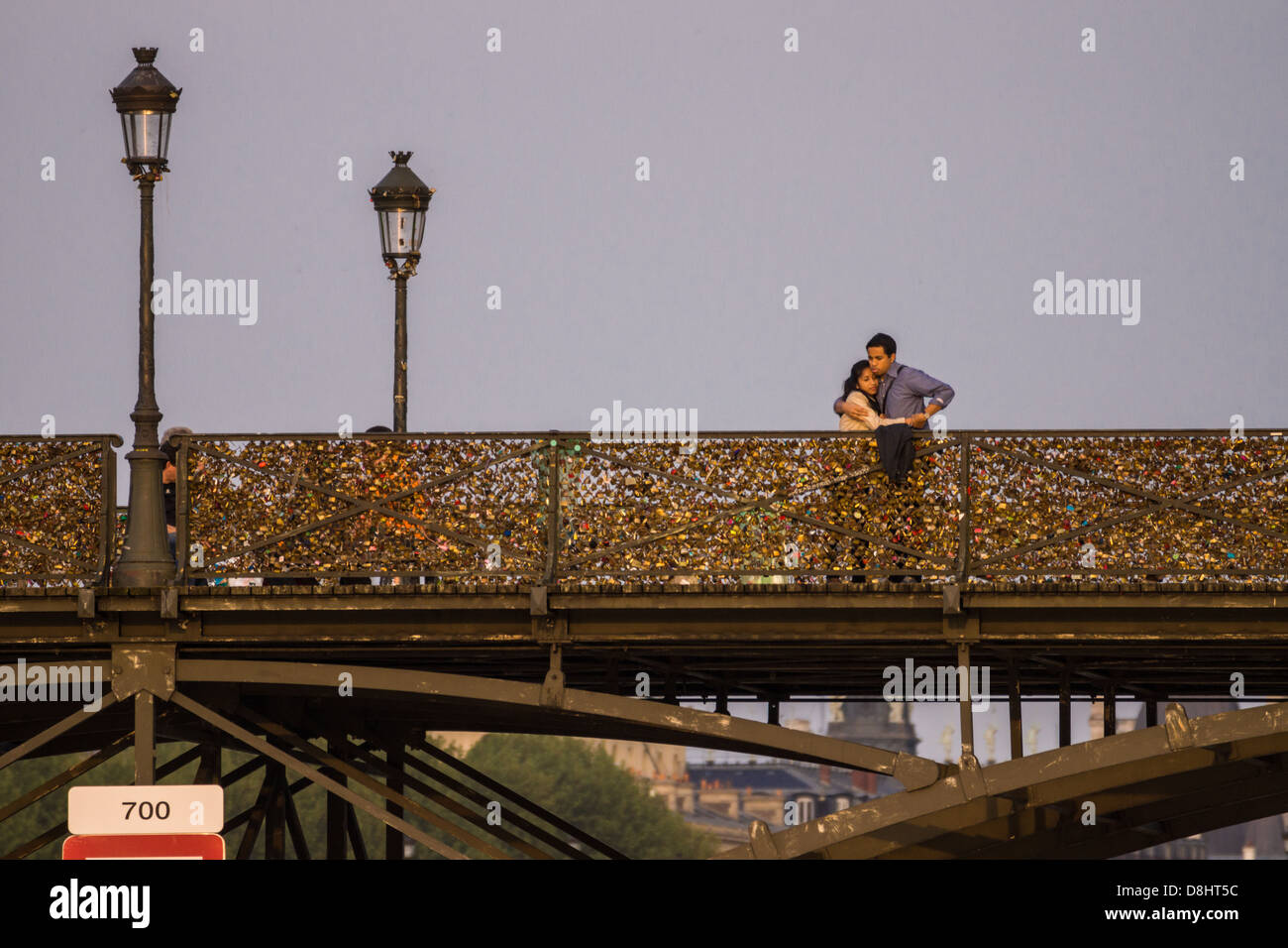 Paris, France. A loving couple hugs on the bridge at Pont des arts ...