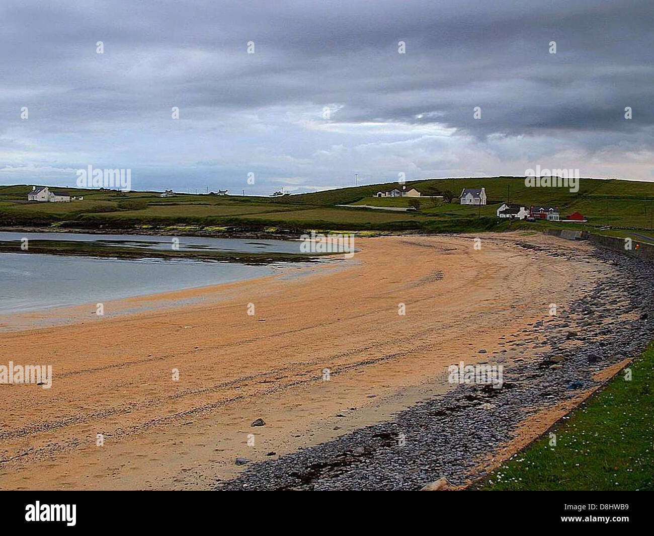 A picturesque beach in Ireland at evening, with soft sunlight casting a ...