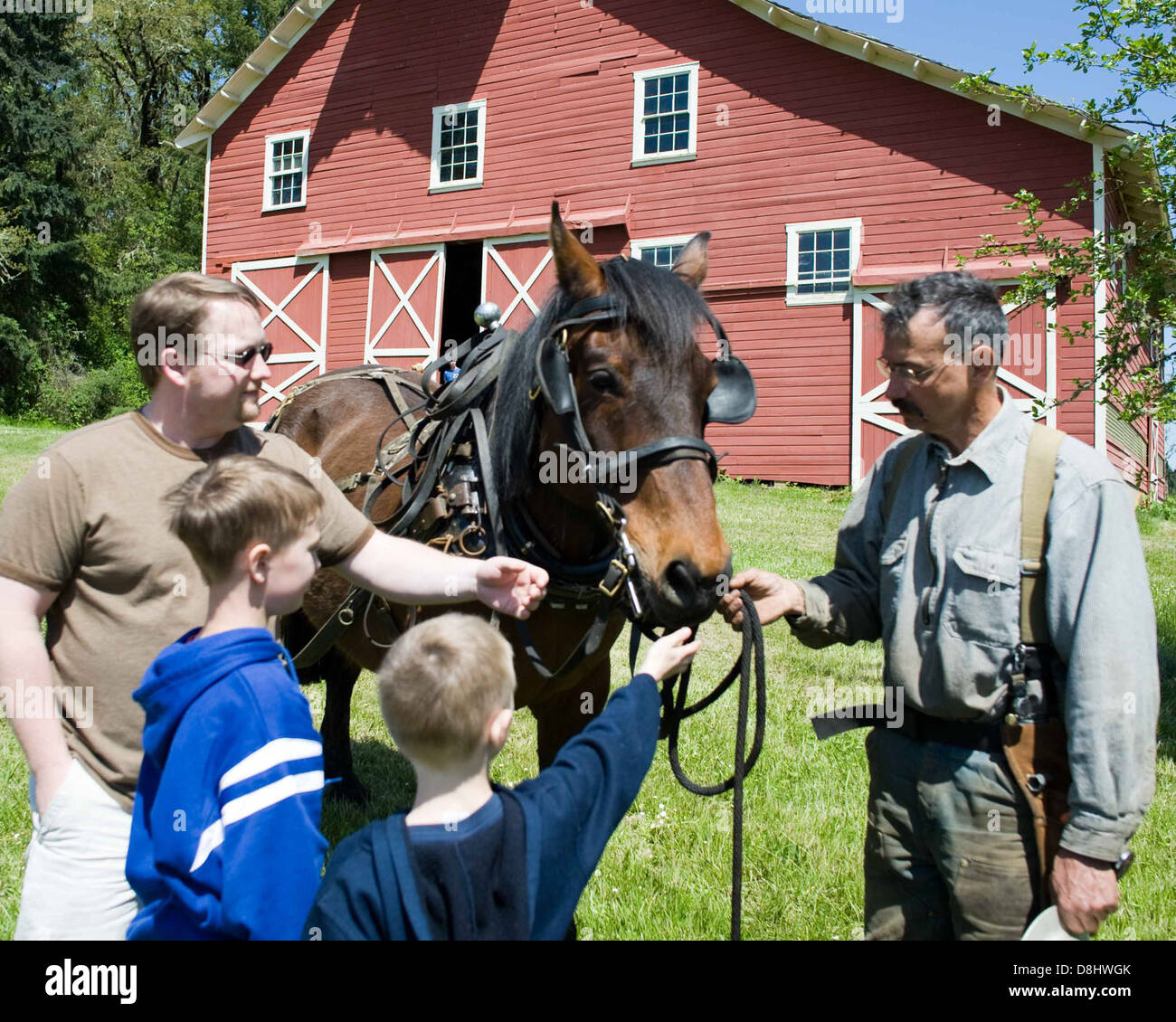 A farmer engages in conversation with a group of people in front of a ...