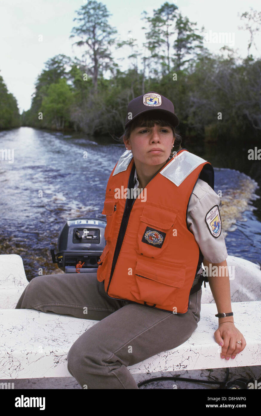 A female employee, dressed in a uniform, is operating a small motor ...