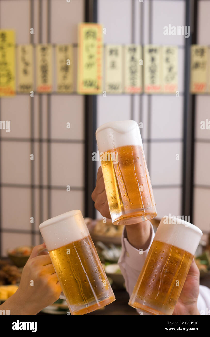 Three People Toasting with Beer at Izakaya Stock Photo - Alamy