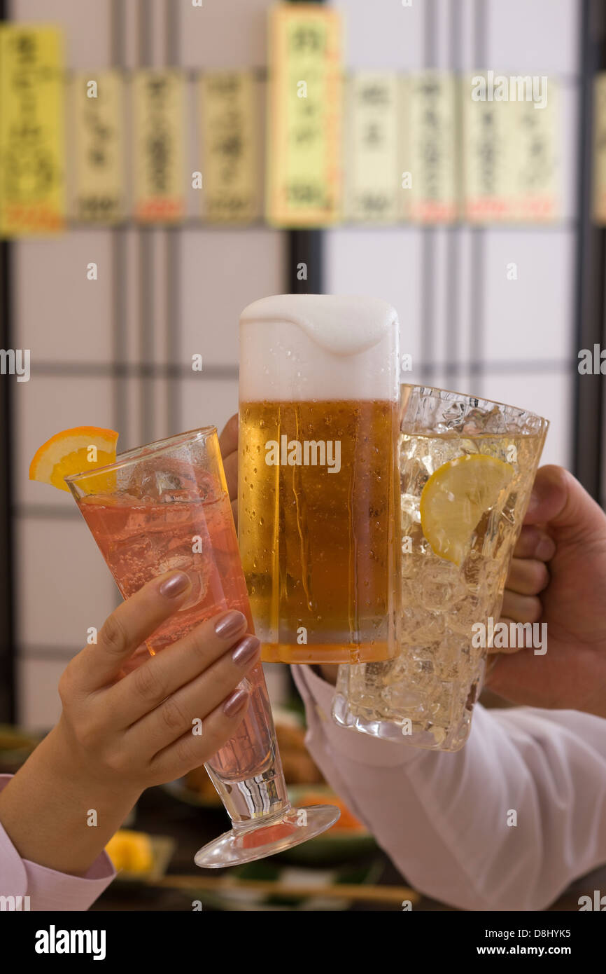 Three People Toasting with Each Other With Various Drinks at Izakaya ...