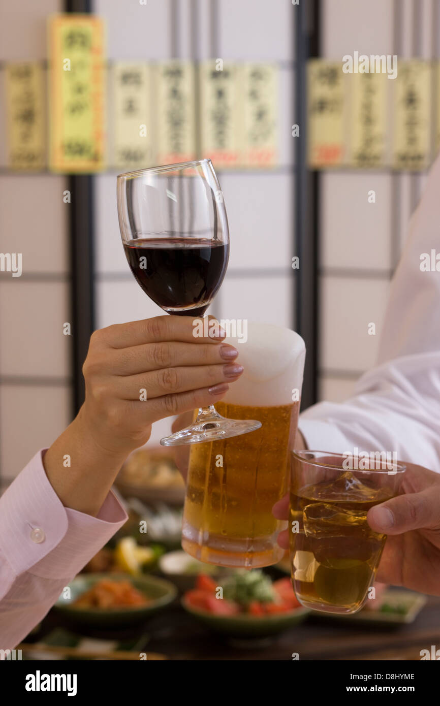 Three People Toasting with Each Other With Various Drinks at Izakaya ...