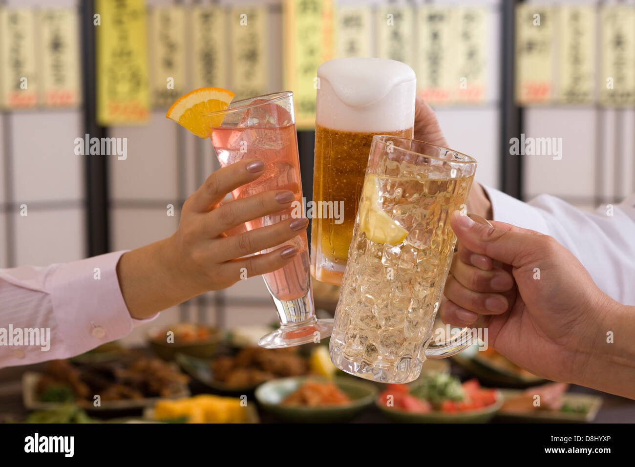 Three People Toasting with Each Other With Various Drinks at Izakaya ...
