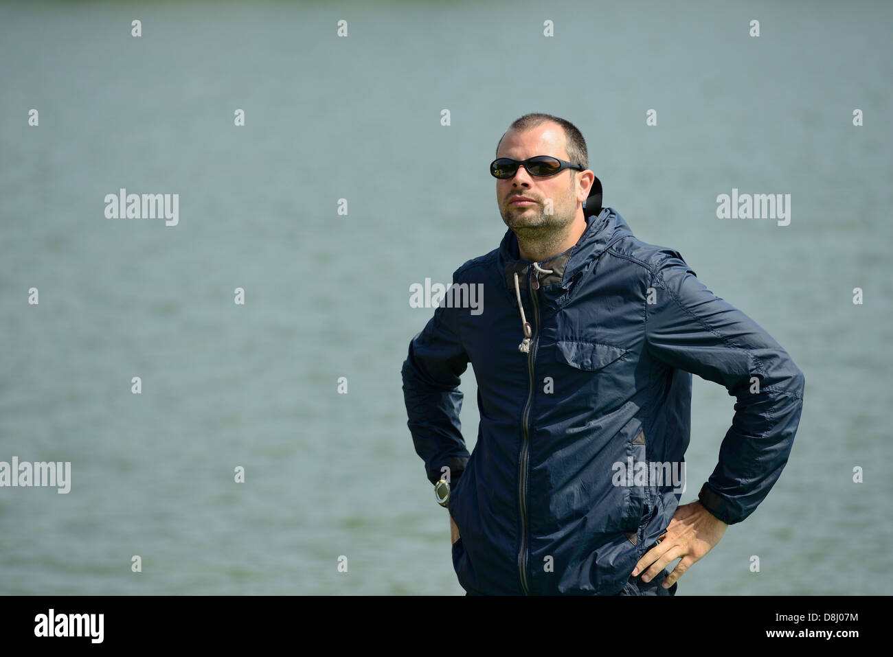 Man standing with arms akimbo Stock Photo - Alamy