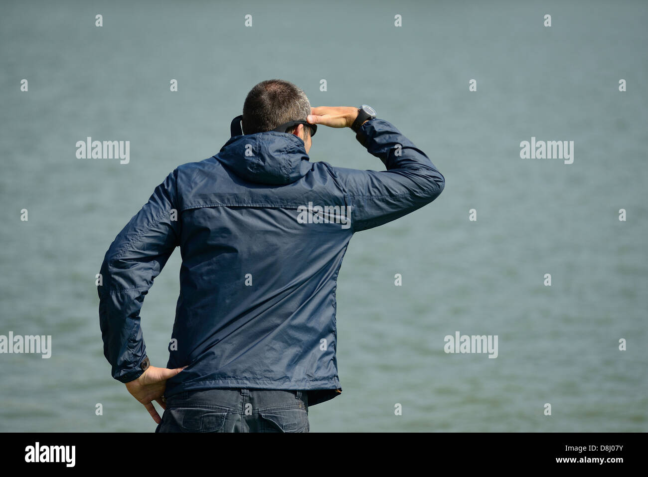 Man looking into the distance surrounded by water Stock Photo - Alamy
