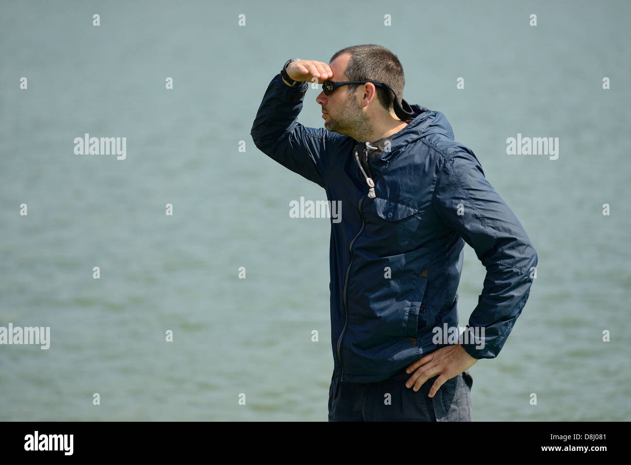 Man looking into the distance surrounded by water Stock Photo - Alamy