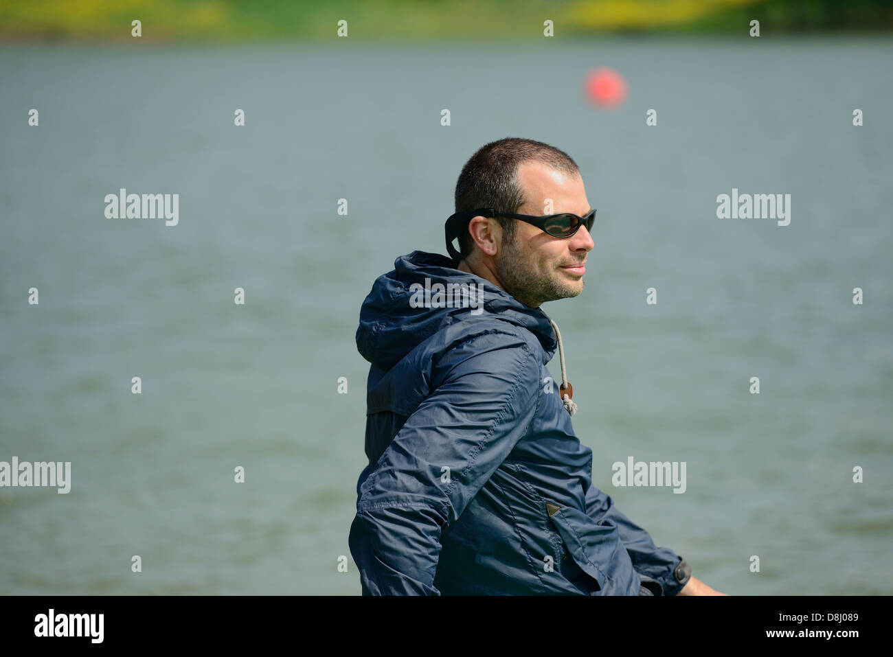 Man turning around with a sea bay behind him Stock Photo - Alamy