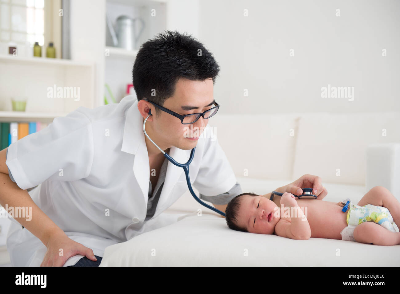 Good looking asian doctor and newborn baby on the clinic , monitoring ...