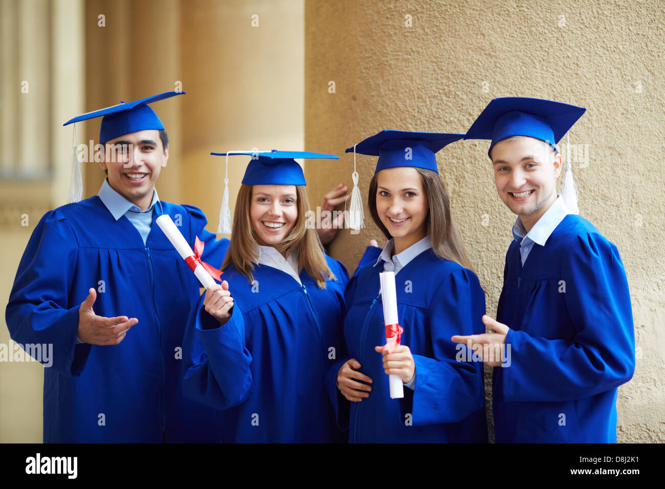 Group of smart students in graduation gowns looking at camera Stock ...