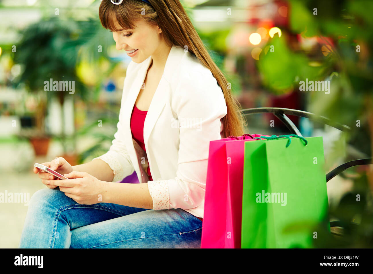Pretty lady with colorful shopping bags sitting in trade center and ...